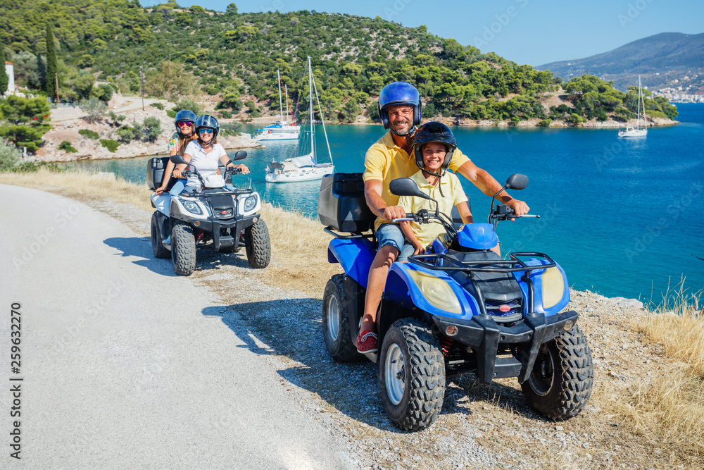 Family riding quad bike. Cute boy and his father on quadricycle. Motor ...