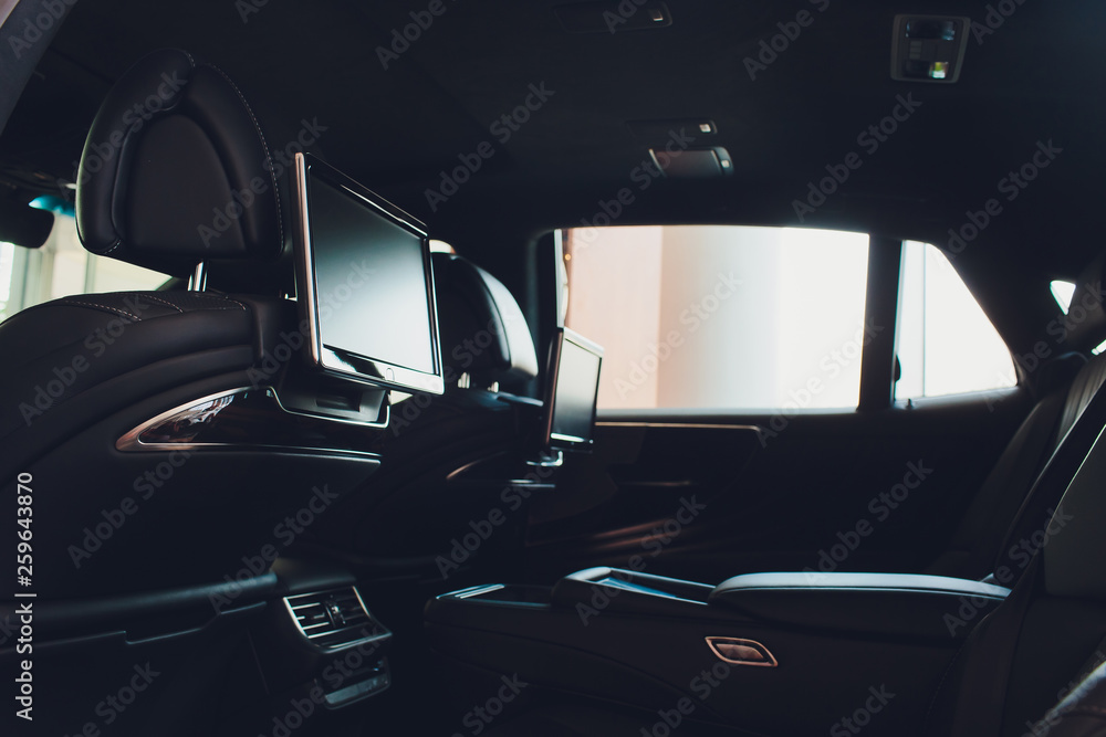 Car inside. Interior of prestige luxury modern car. Three TV displays ...