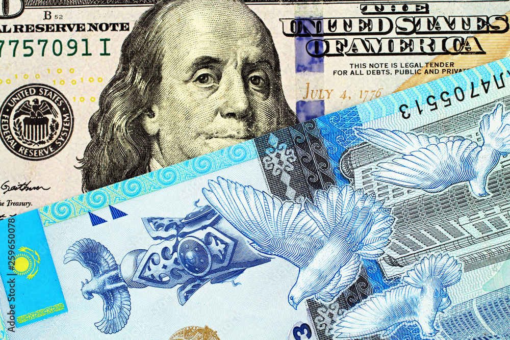 An American one hundred dollar bill close up with a five hundred tenge ...