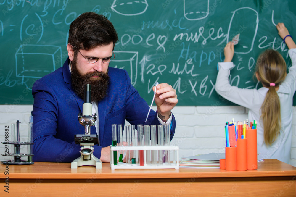Performing an experiment. Teacher and pupil. Male teacher giving lesson ...