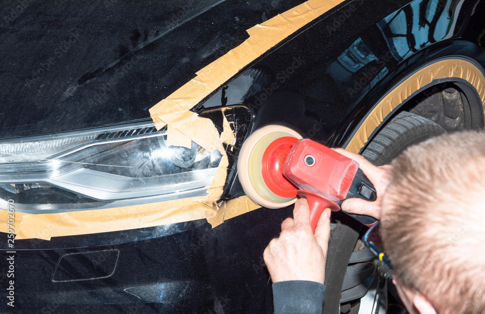 Professioneller Autolackierer poliert ein Fahrzeugteil mit der ...