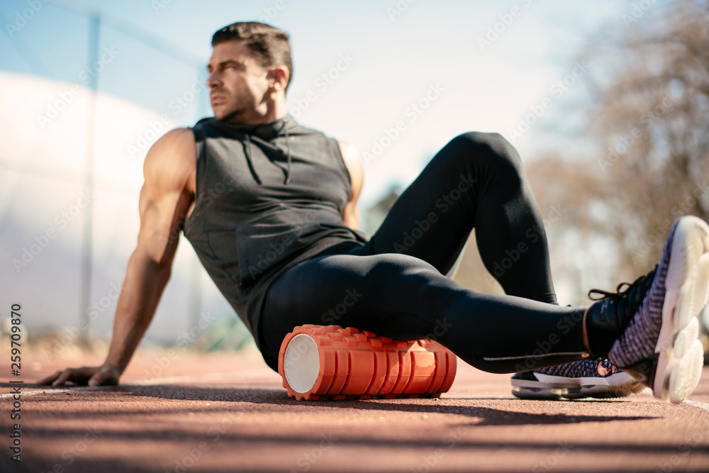 Man foam rolling. Athlete stretches using foam roller. Stock Photo ...