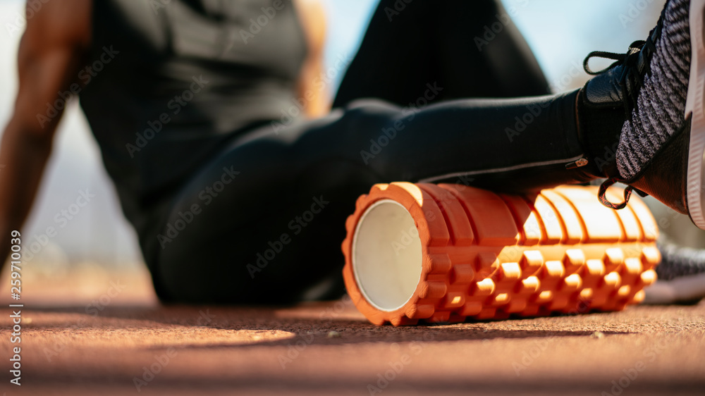 Man foam rolling. Athlete stretches using foam roller. Stock Photo ...