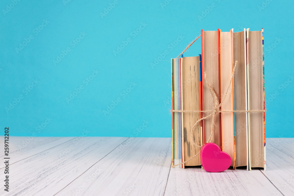 Stack of books and pink heart. Books with jute ribbon bow as gift on ...