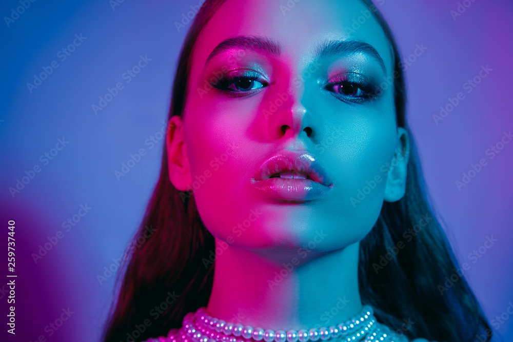 High fashion model in colorful bright neon lights posing at studio ...
