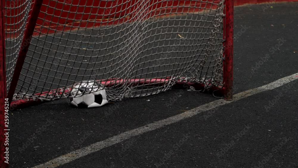 Outworn and deflated but rather new soccer ball run into small gate ...