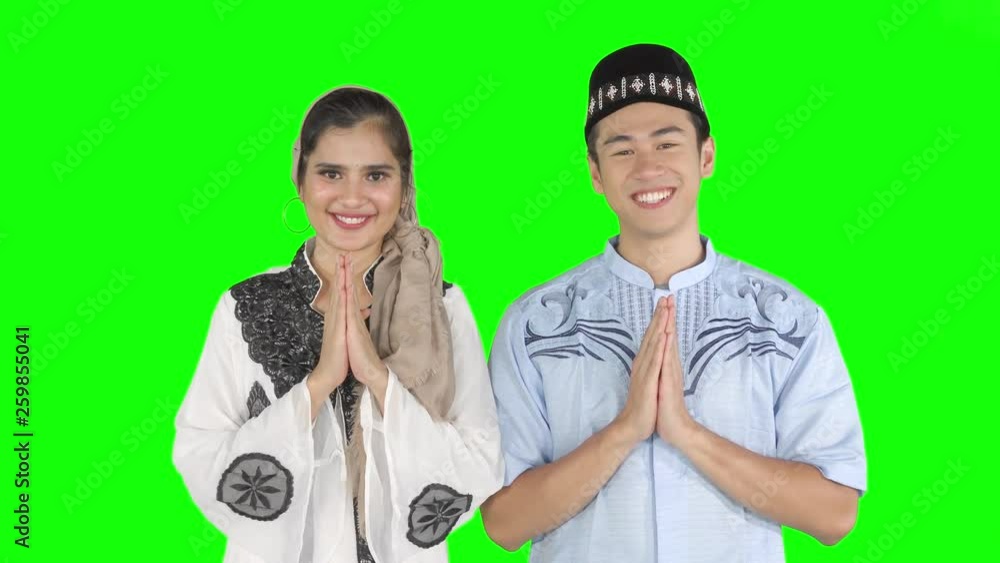 Young muslim couple showing a greeting hands gesture while smiling at ...
