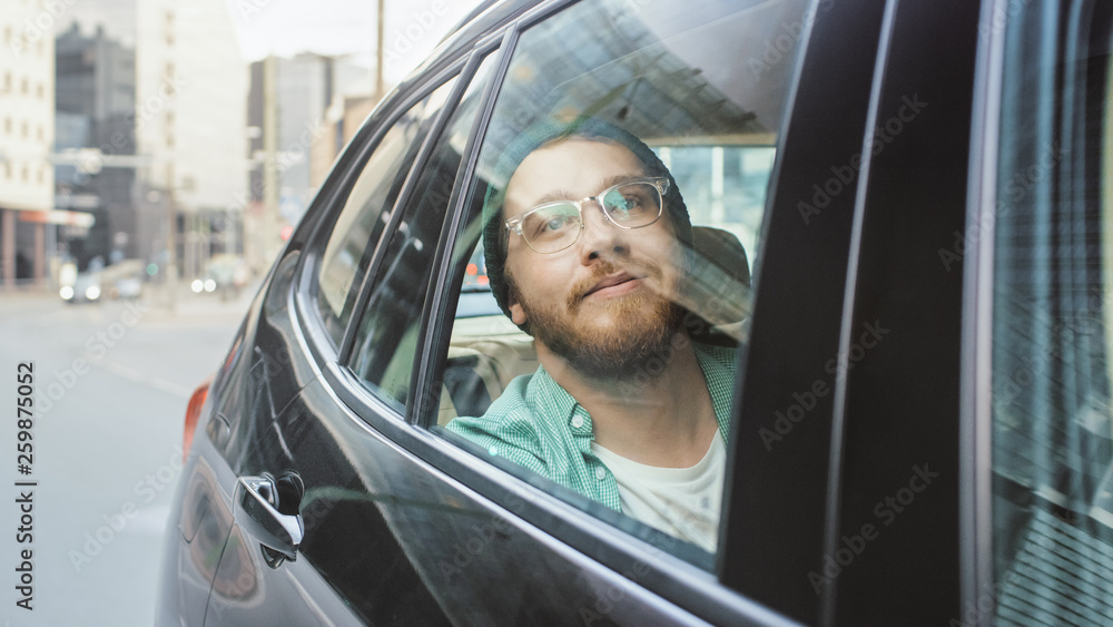 Stylish Young Man Rides on a Passenger Back Seat of a Car, Looks out of ...