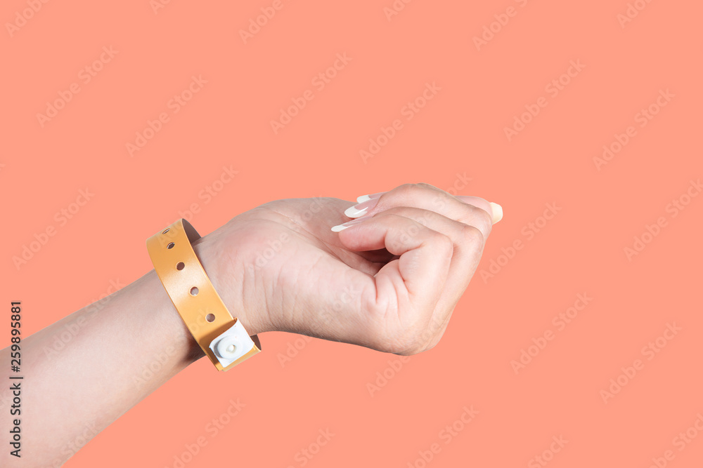 Closeup view of female hand wearing brown entrance wristband of hotel ...