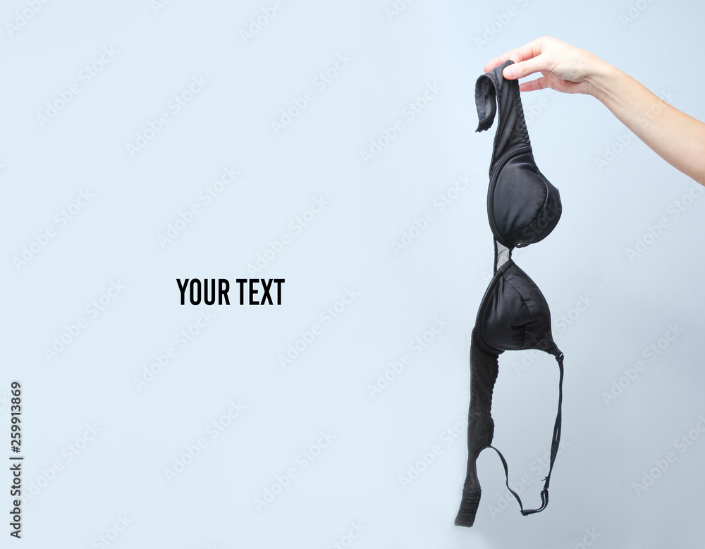 Female hand holding black bra on gray background. Copy space Stock ...