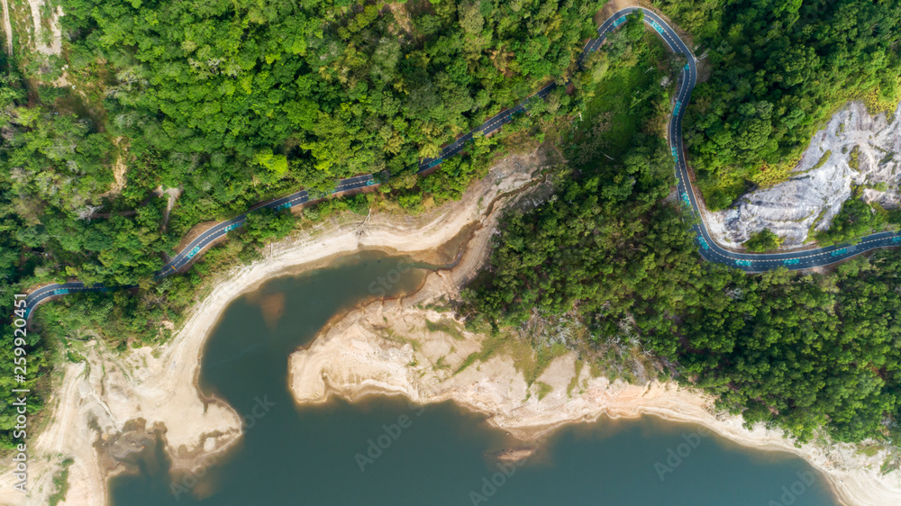 Top down from Drone aerial view of rainforest with asphalt road around ...