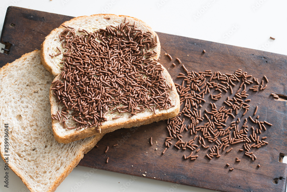 slice of brown bread with typical Dutch chocolate hail called hagelslag ...