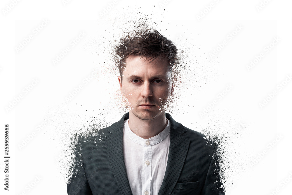 Man breaks into particles. A man model in a suit and white shirt, on a ...