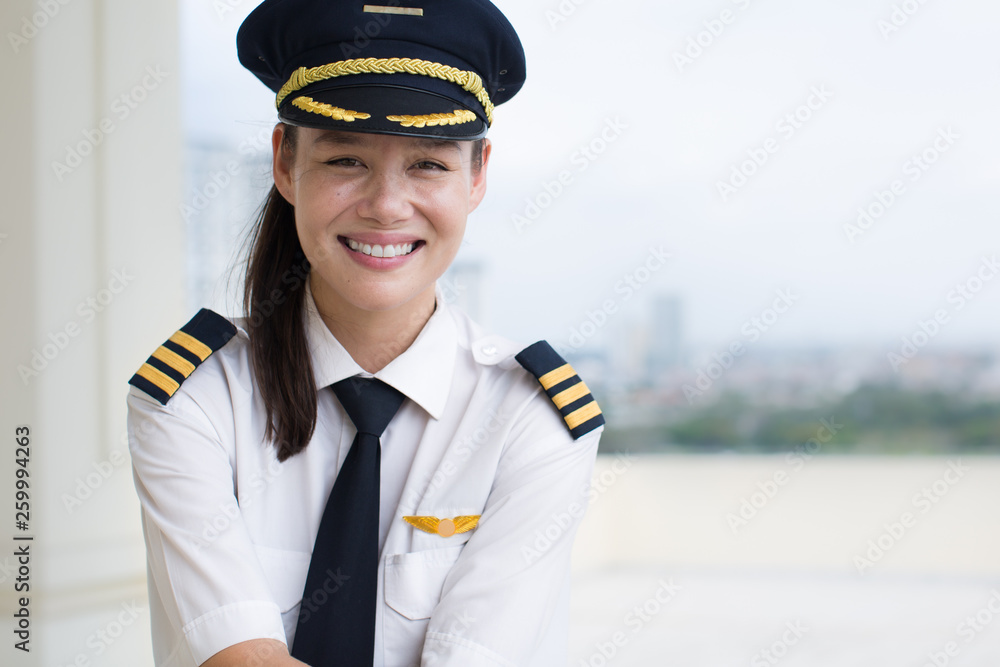 Portrait of a pretty female pilot smiling. Stock Photo | Adobe Stock