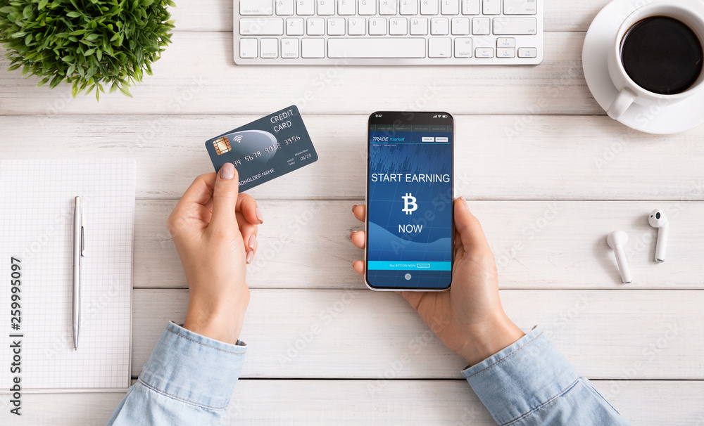 Woman using credit card and bitcoin earning mobile app Stock Photo ...