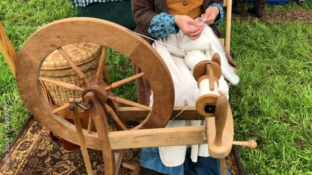 HD video close up on spinning wheel with woman in old colonial dress ...
