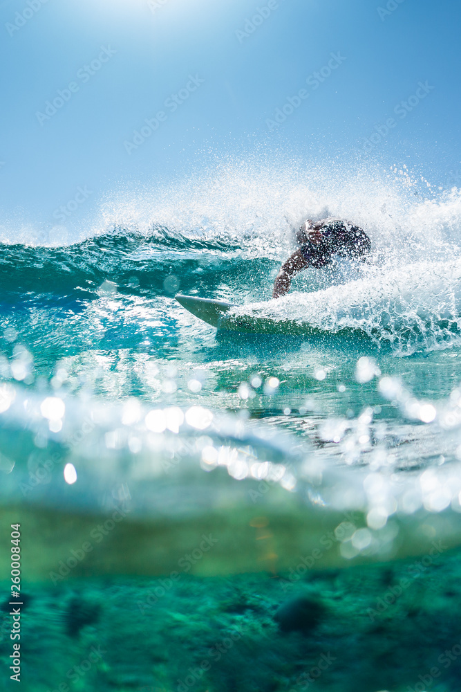 Surfer rides the ocean wave with lots of splashes and underwater view ...