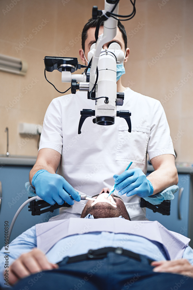 Your pathway to a bright new smile. Male dentist look at the patient ...