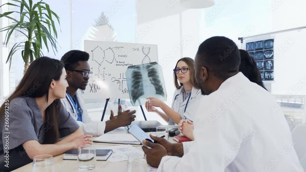 Group of qualified doctors are analyzing x-ray of lungs a patient's ...