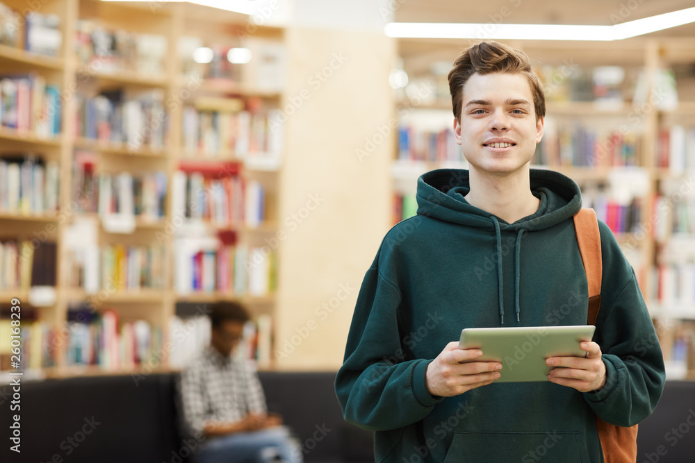 Portrait of smiling modern student guy in dark green hoodie wearing ...