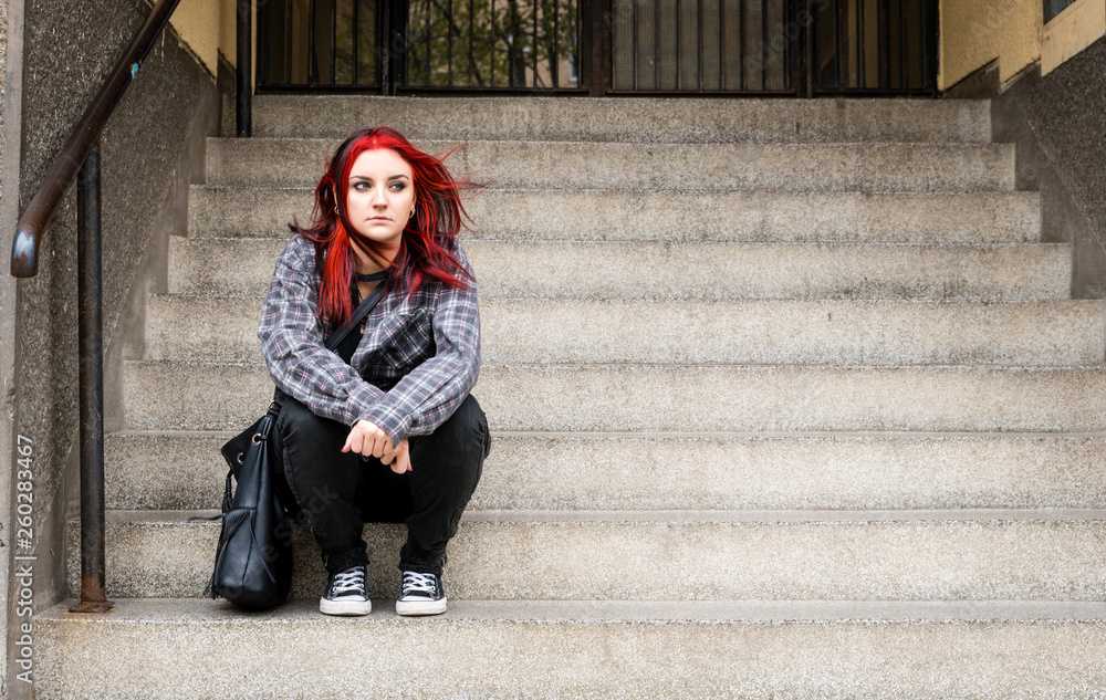 Homeless girl, Young beautiful red hair girl sitting alone outdoors on ...