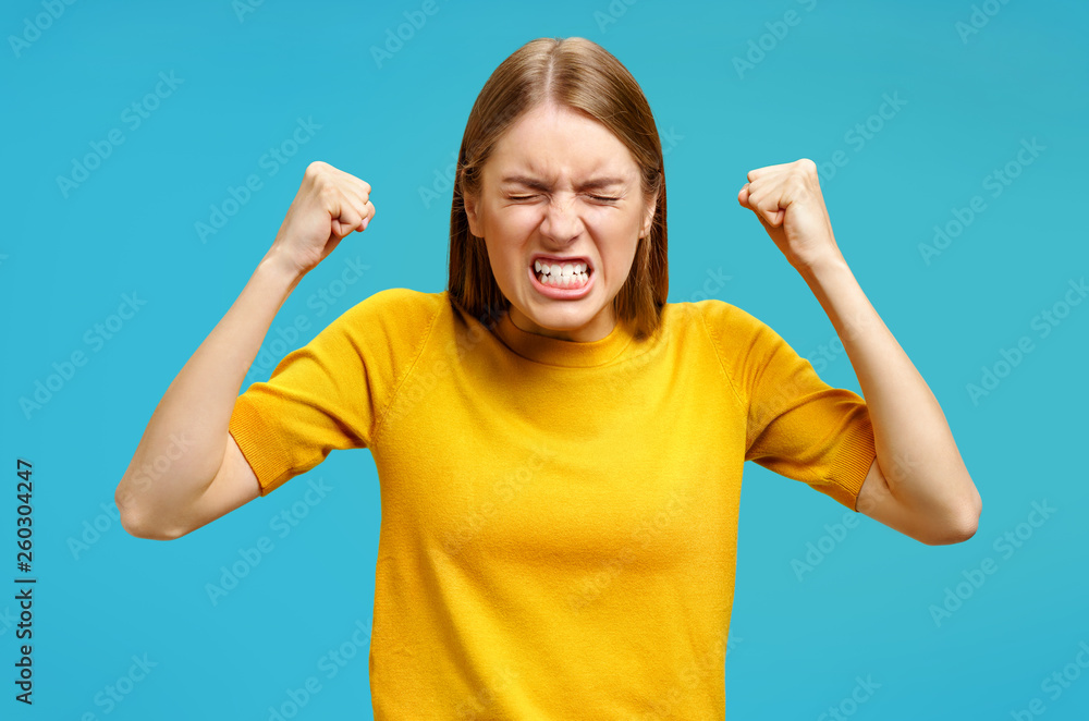 Foto de Aggression girl with widely open mouth and clenched teeth holds ...