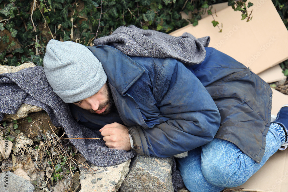 Poor homeless man lying on street in city Stock Photo | Adobe Stock