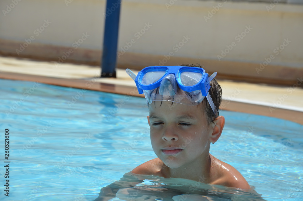 Teenager boy wearing mask swimming in the pool. Happy holiday concept ...