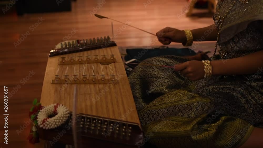 Close-up of Thai or chinese musician playing a traditional zither khim ...