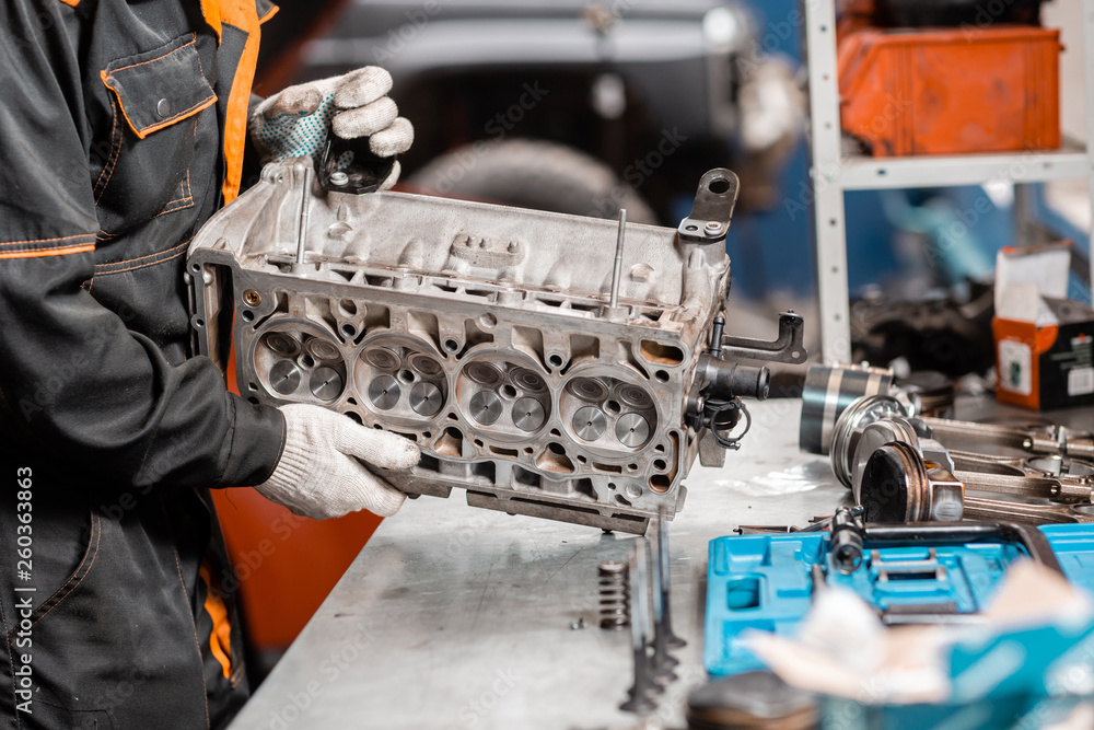 Foto de Mechanic disassembling the engine, overhaul.. Engine on a ...