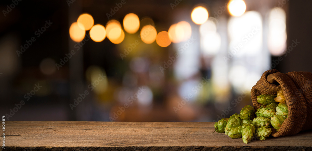 Hop twigs frame over wooden cracked table background. Vintage toned ...