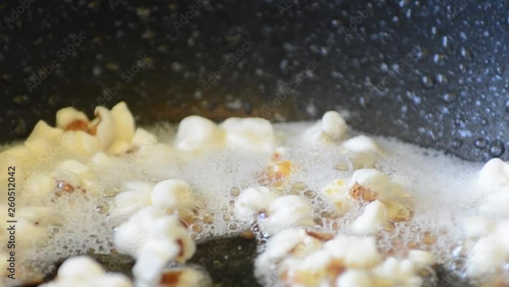 Popcorn is boiled in hot boiling vegetable oil, explodes and shoots up ...