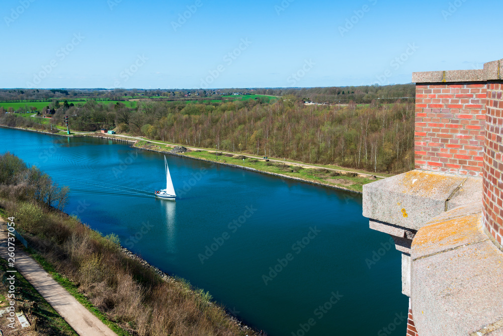 Blick von der Levensauer Hochbrücke über den Nord-Ostsee-Kanal. Eine Segelyacht passiert den ...