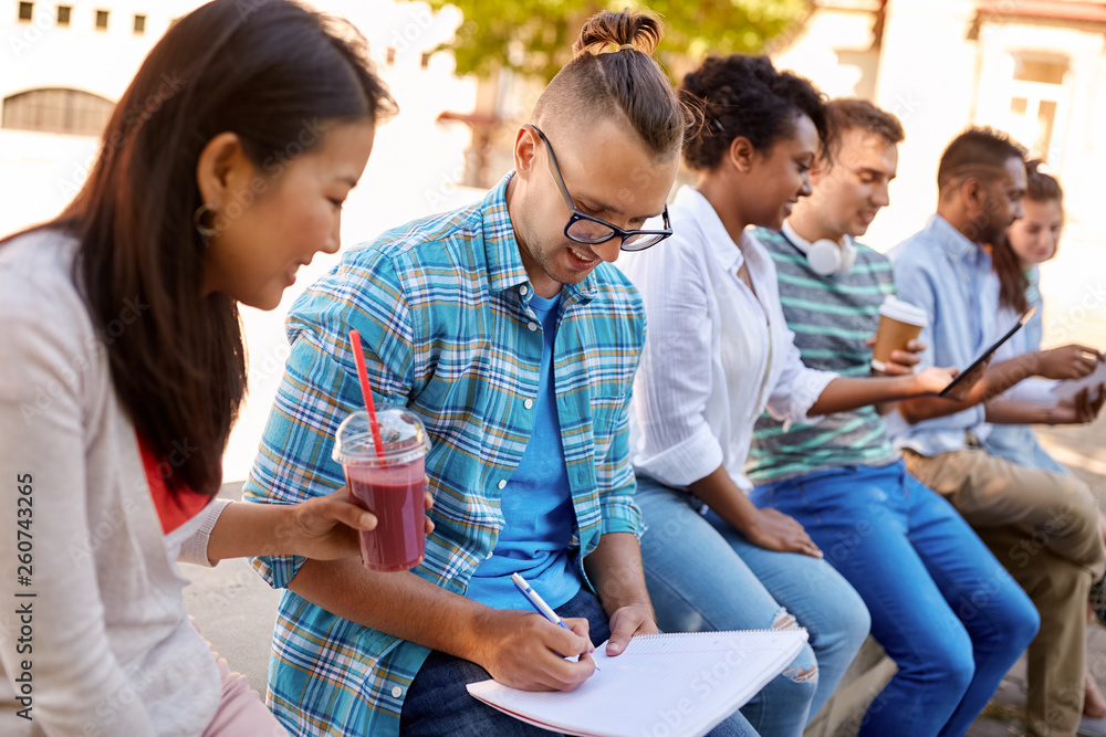 education and people concept - group of happy students with notebook ...