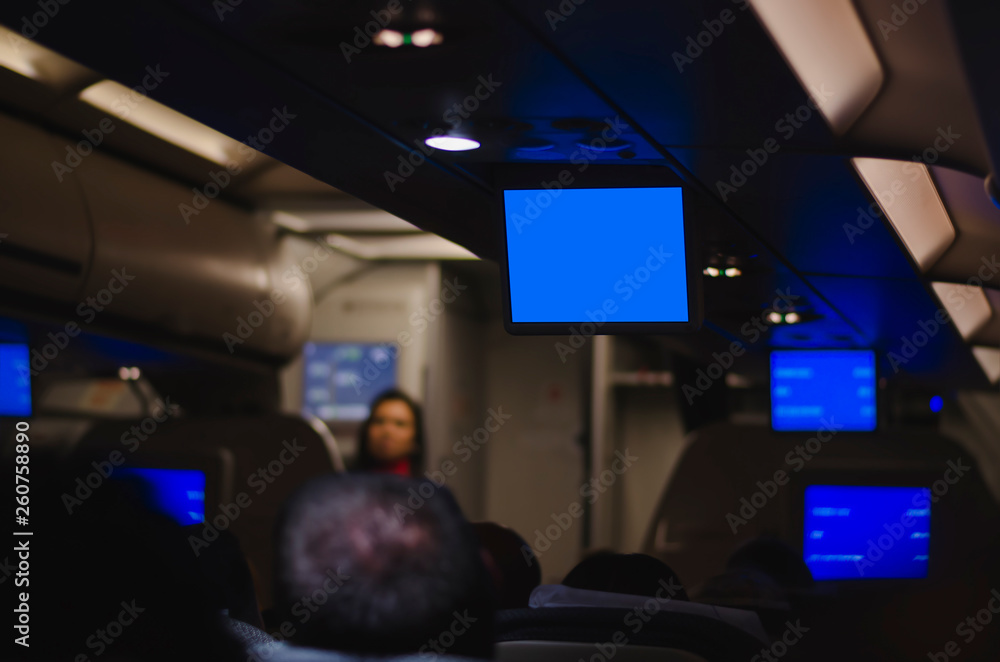 Inside an airplane during a flight with the informative tv screens down ...