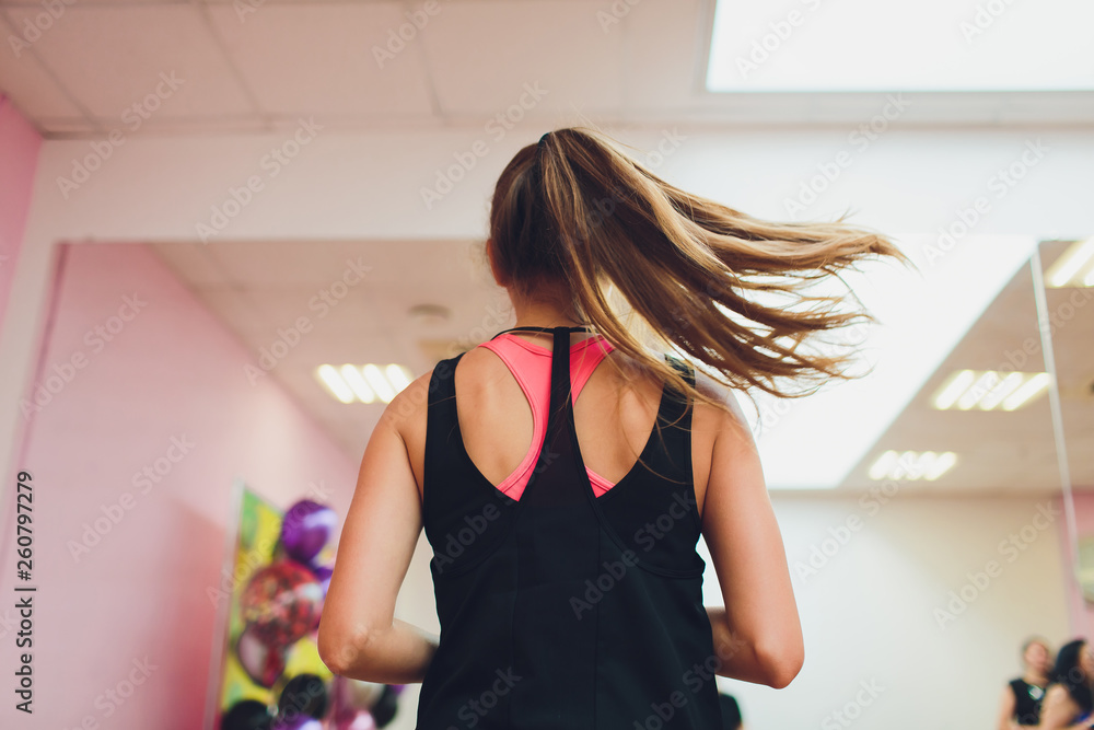 back view of jumping woman in jeans. beautiful blonde girl in motion ...