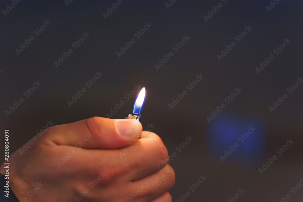 Burning lighter in a man's hand. Blue flame of a lighter. The texture ...