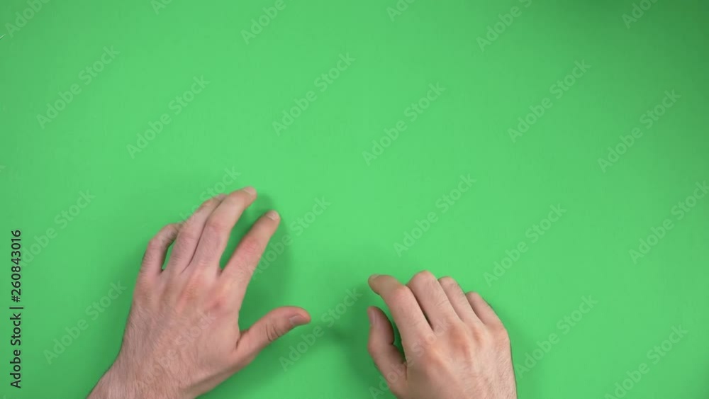 Hands making multiple gestures on a huge green screen simulating a ...