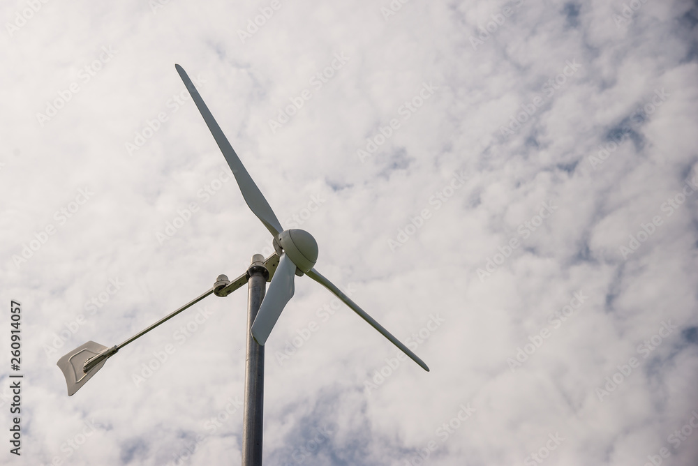 Small wind turbine on sky with cloud as background Stock Photo | Adobe ...