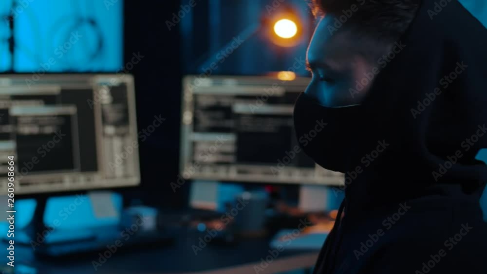 cybercrime, hacking and technology concept - young asian hacker wearing ...