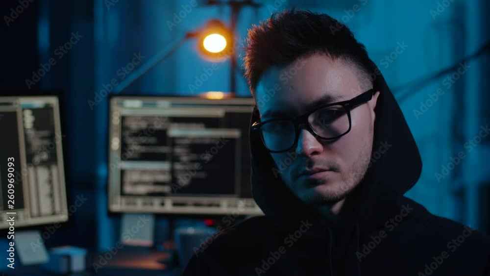 cybercrime, hacking and technology concept - young asian hacker wearing ...