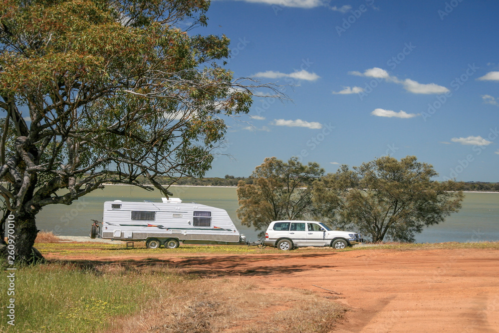 Four wheel drive vehicle and large caravan at roadside stop next to a ...