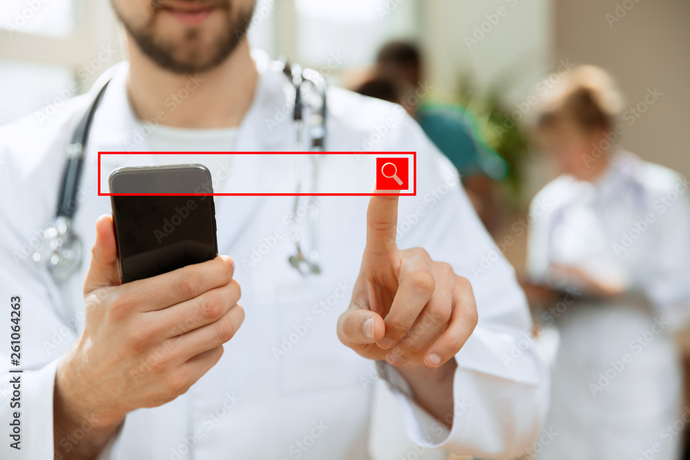Professional caucasian male doctor with phone at hospital office or ...