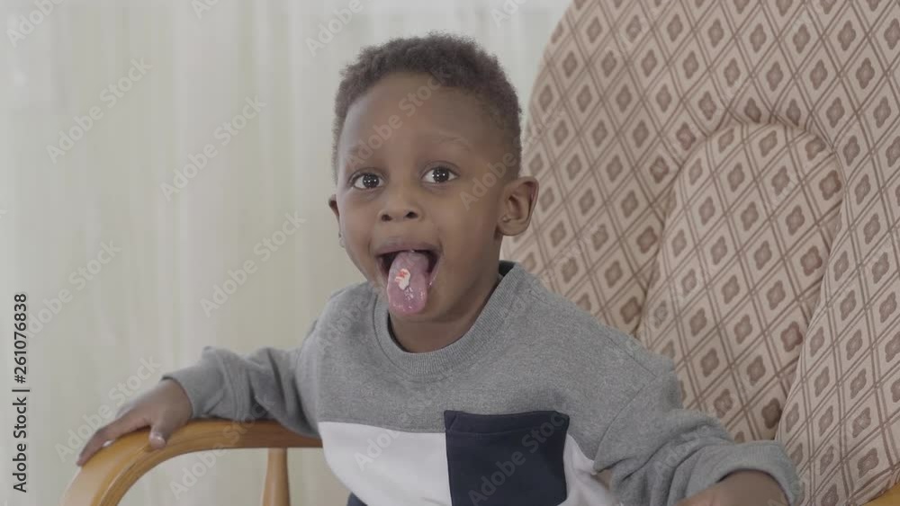 Portrait of funny african american child boy chewing gum or candy and ...