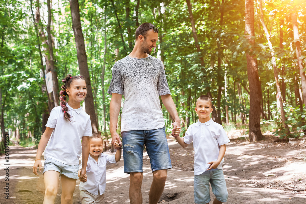 Happy father with three children in sunny summer forest holding their ...