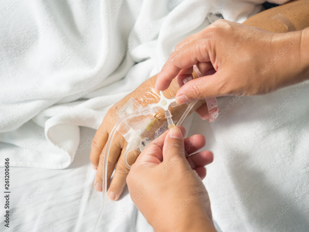 Close up nurse hand adjust set iv fluid intravenous drop saline drip in ...