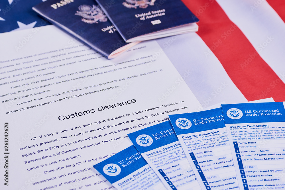 Page of paper with words Customs Clearance next to American passports ...