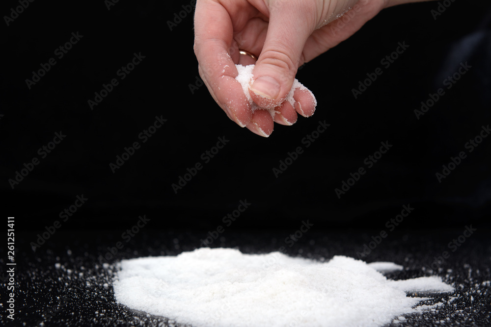 in the fingers of a young woman a pinch of salt, which she pours down ...