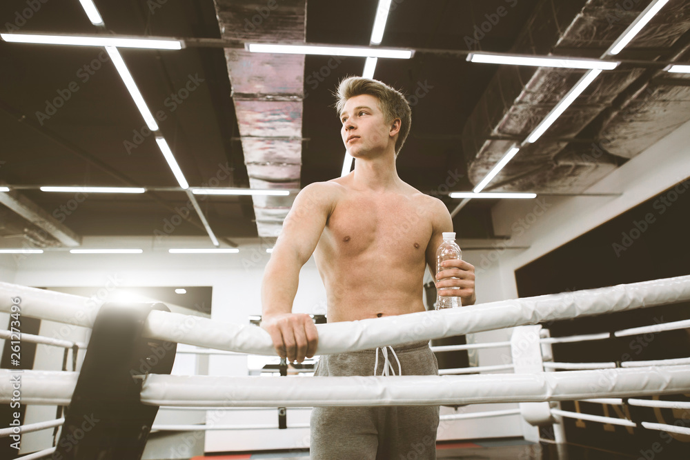 Young athletic man resting after hard training to box, fighting on the ...
