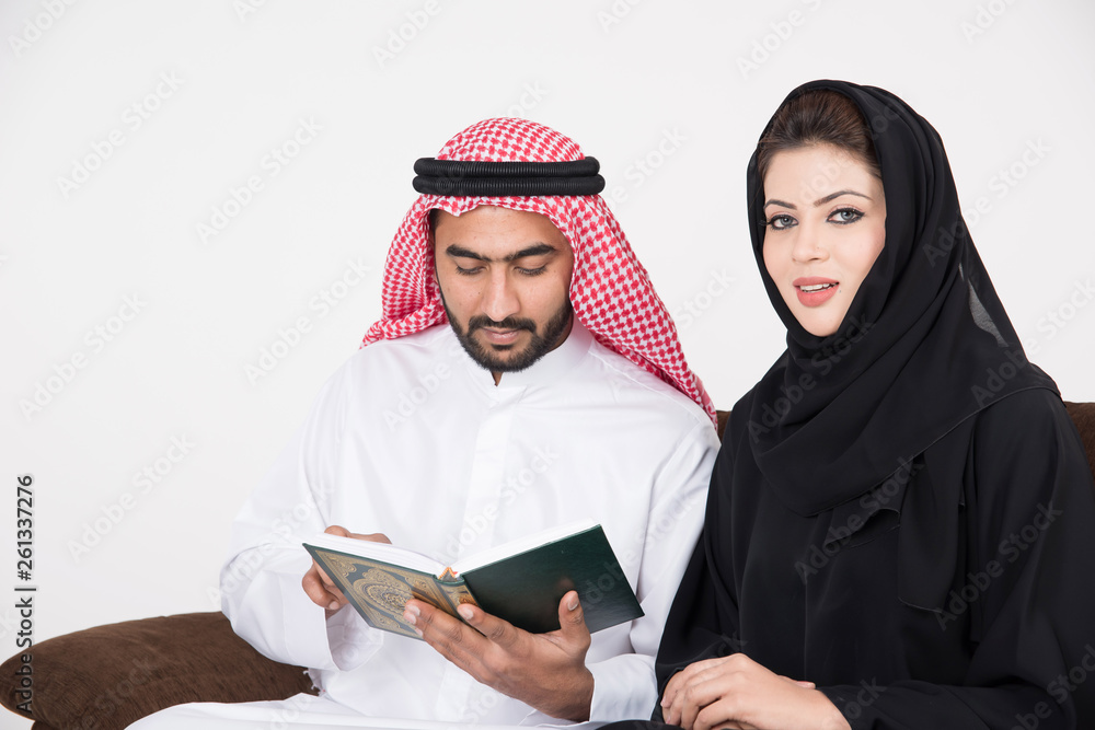 Foto de Arab man reading from the Holy Quran for his wife while sitting ...